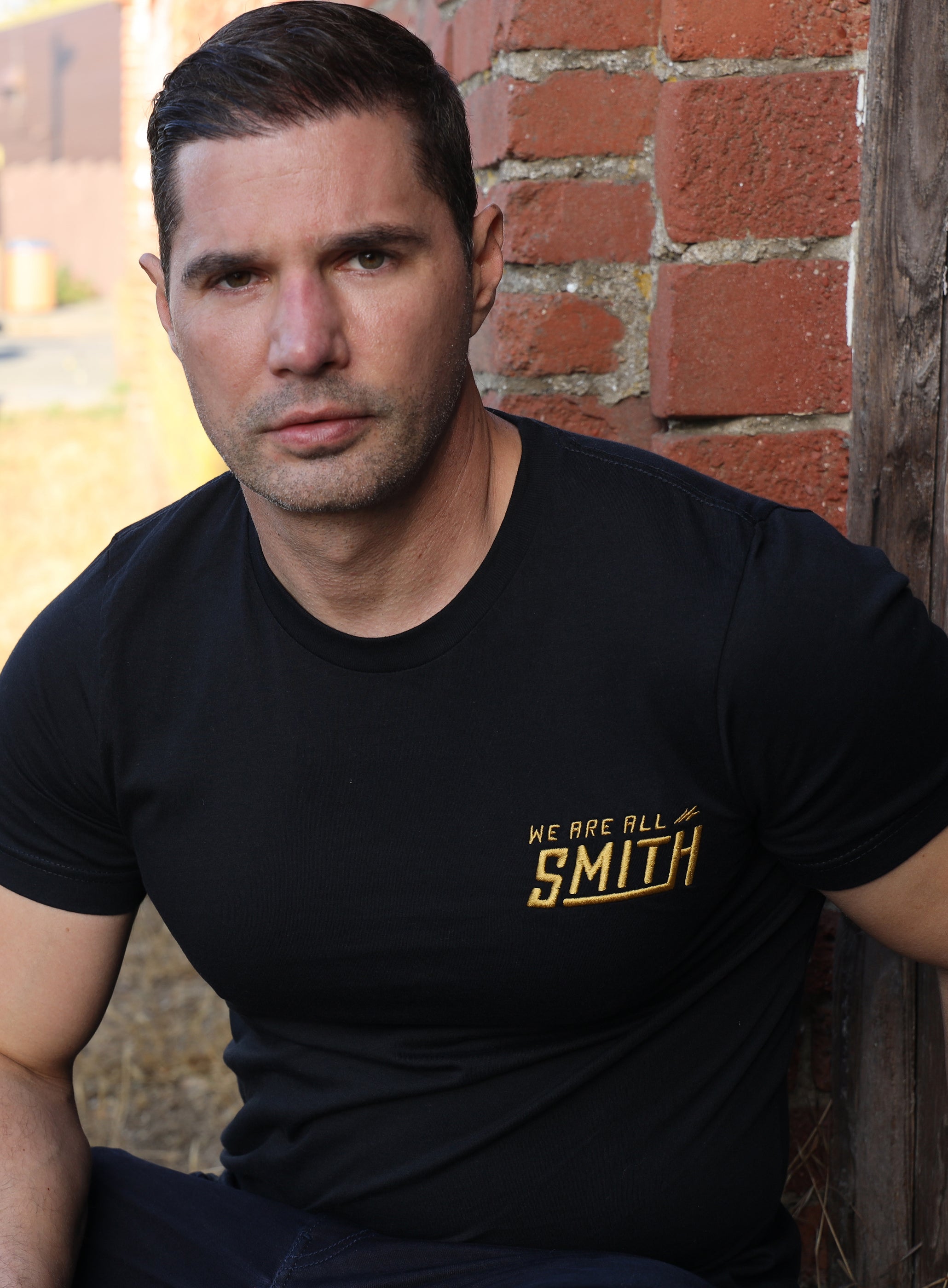 Gold We Are All Smith Embroidered Logo Black Unisex t-shirt — WE ARE ALL SMITH